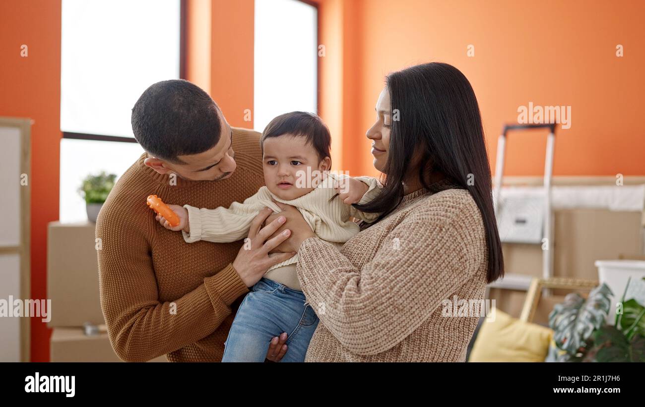 Couple and son hugging each other standing at new home Stock Photo - Alamy