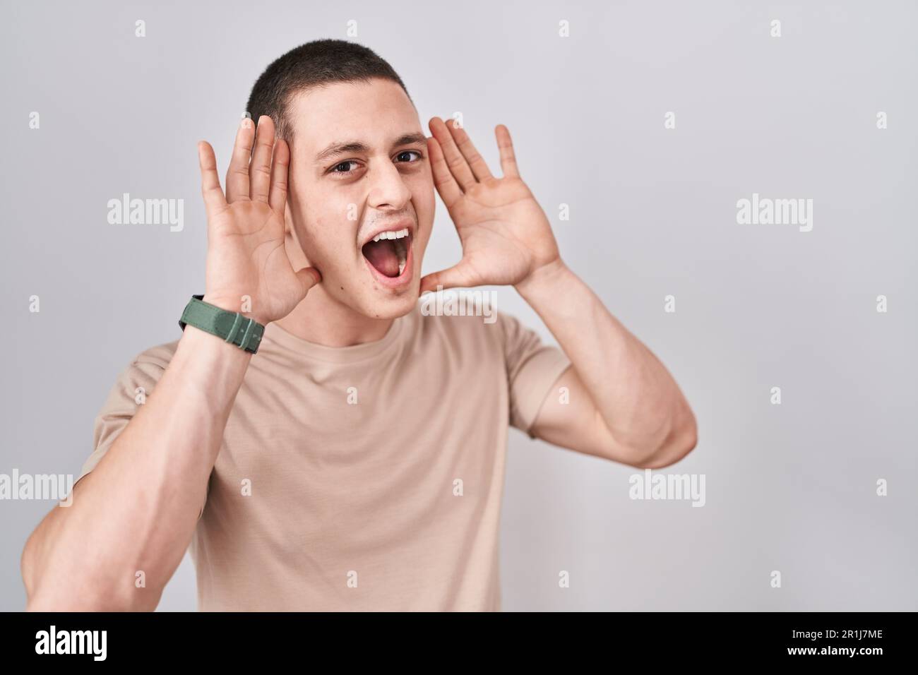 Young man standing over isolated background smiling cheerful playing ...