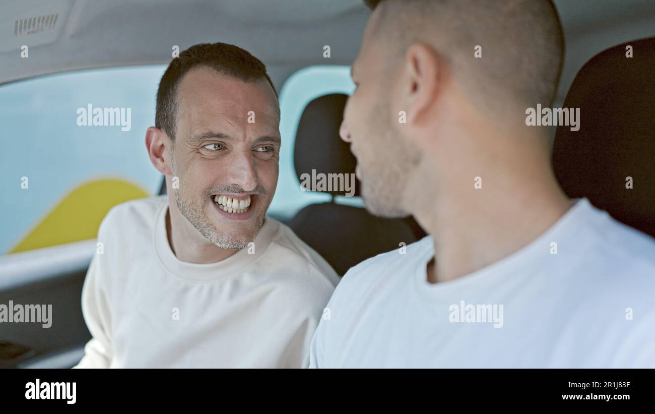 Two men couple driving car speaking at street Stock Photo - Alamy