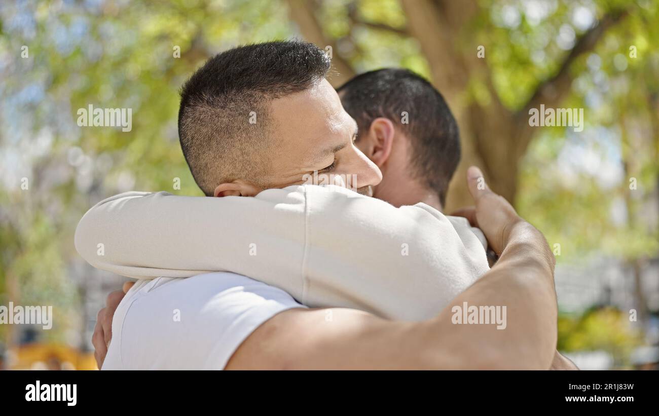 Two men couple hugging each other at park Stock Photo - Alamy