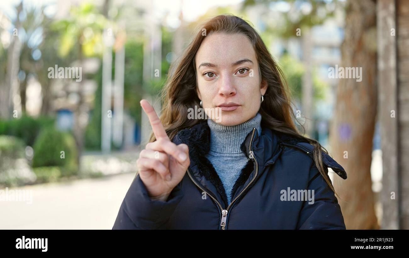 Young caucasian woman standing with serious expression saying no with ...
