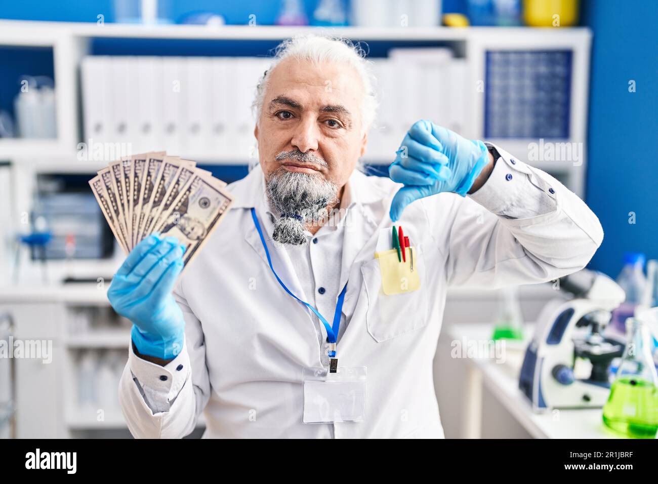 Middle age man with grey hair working at scientist laboratory holding ...