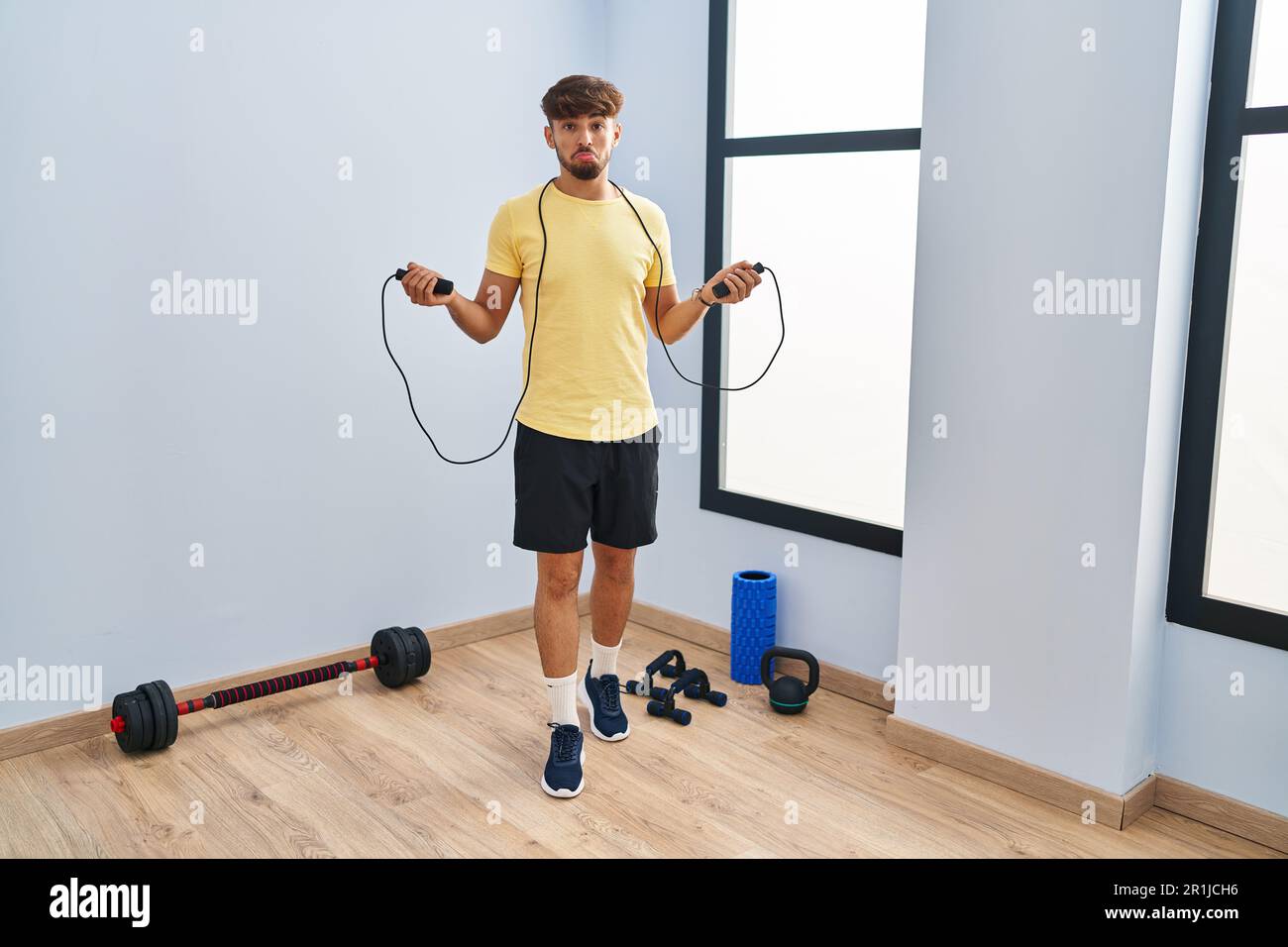 Arab man with beard training with jump rope depressed and worry for ...