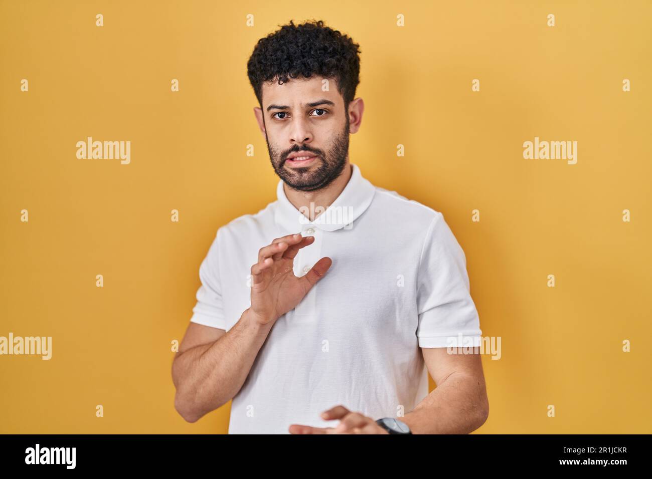 Arab man standing over yellow background disgusted expression ...