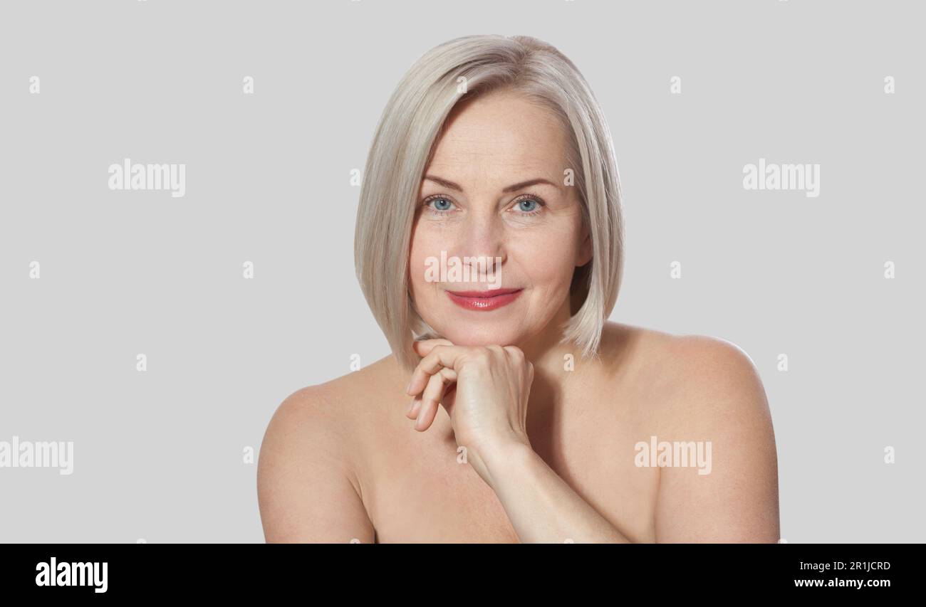 Beautiful middle-aged blonde woman shows off her perfectly well-groomed face. Macro face ...