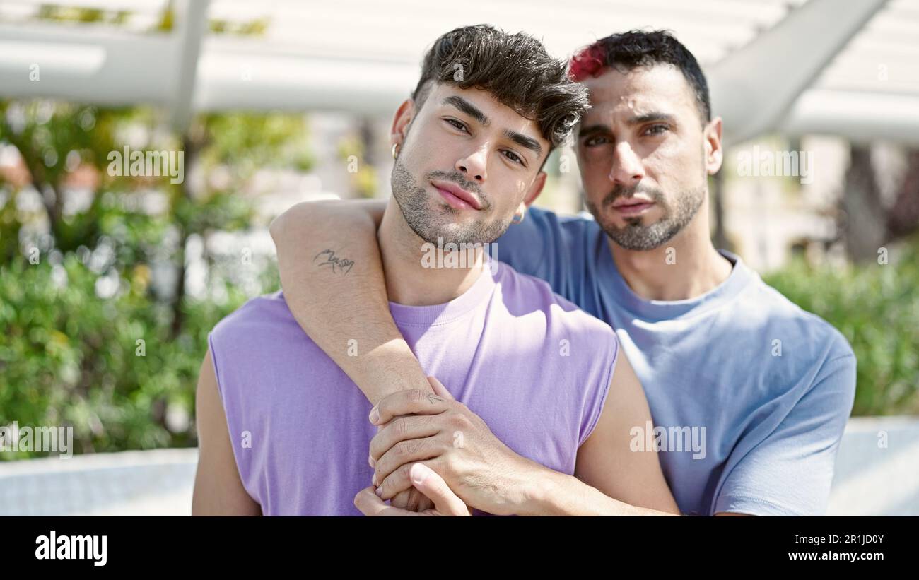 Two men couple hugging each other with relaxed expression at park Stock ...