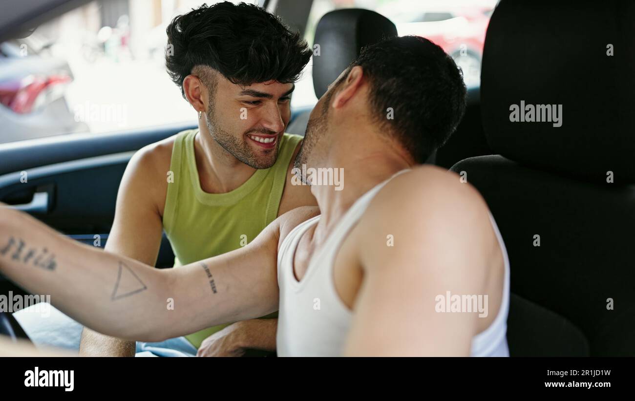 Two men couple smiling confident driving car at street Stock Photo - Alamy