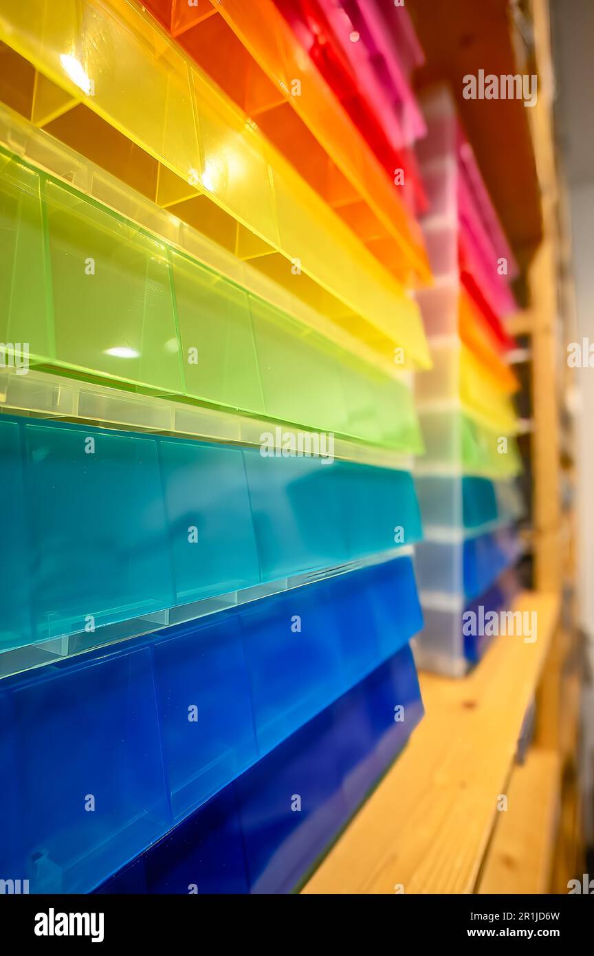 Rows of multi-colored storage bin totes in a retail store shelving ...
