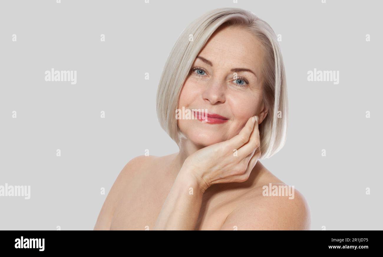 Fifty year old woman is very pleased with her well-groomed face relaxed ...