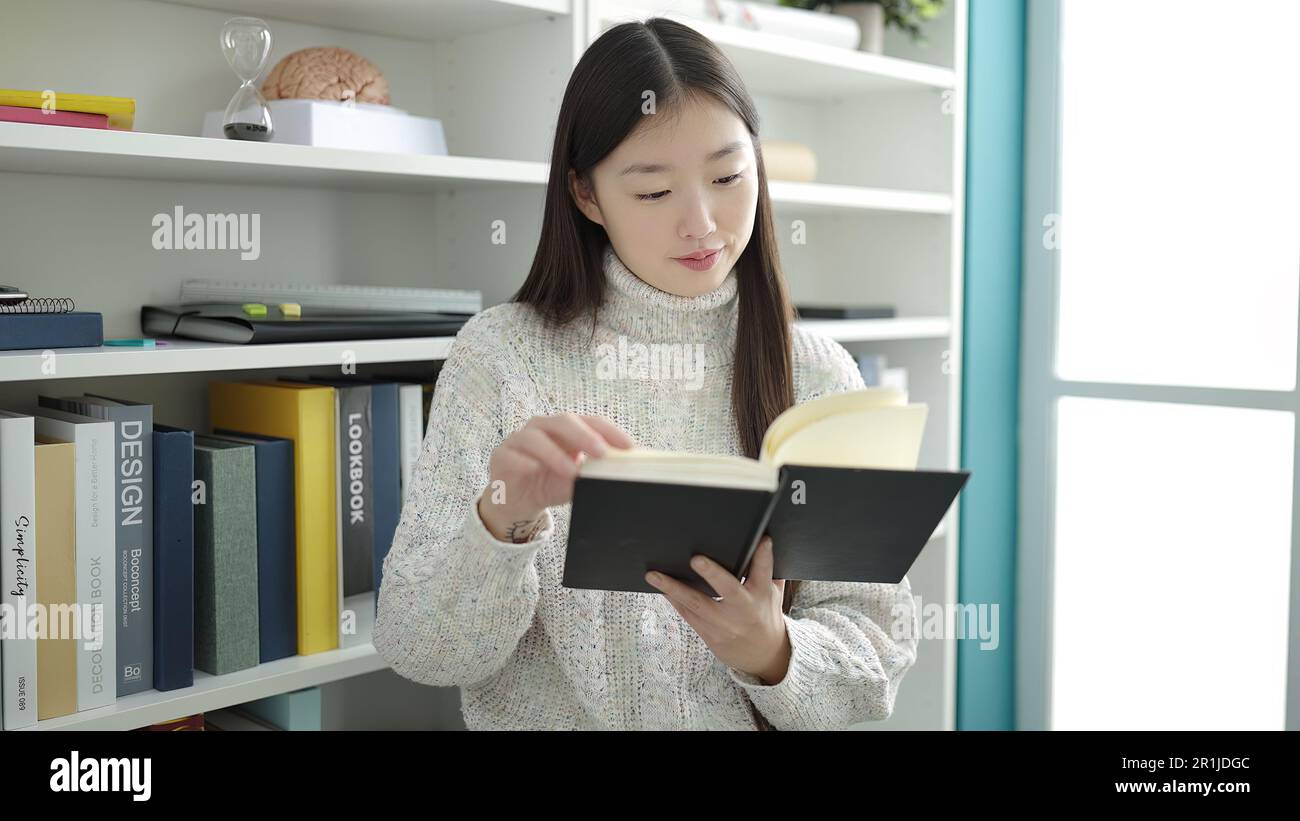 Young chinese woman student reading book studying at library university ...