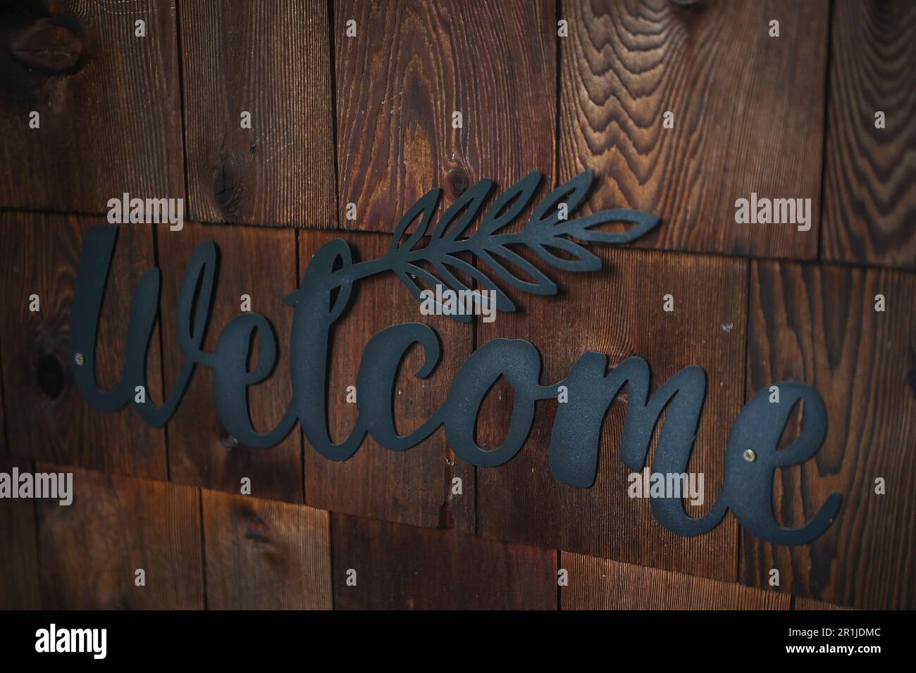 A metal welcome sign on a wood shingle wall Stock Photo - Alamy