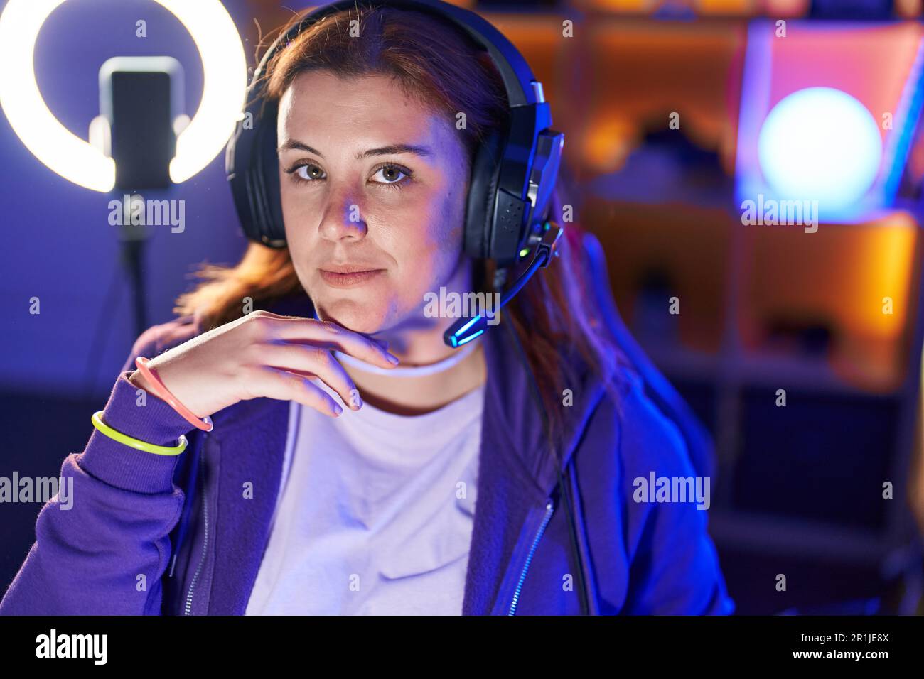 Young beautiful plus size woman streamer sitting on table with relaxed ...