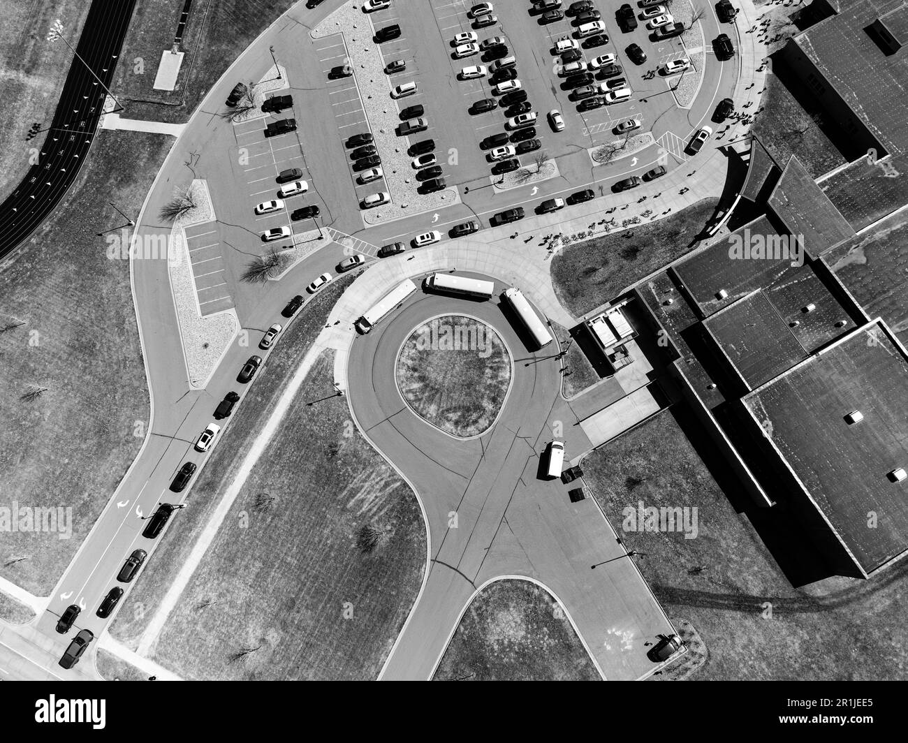 Drone overhead aerial view of a school letting out students at the end ...