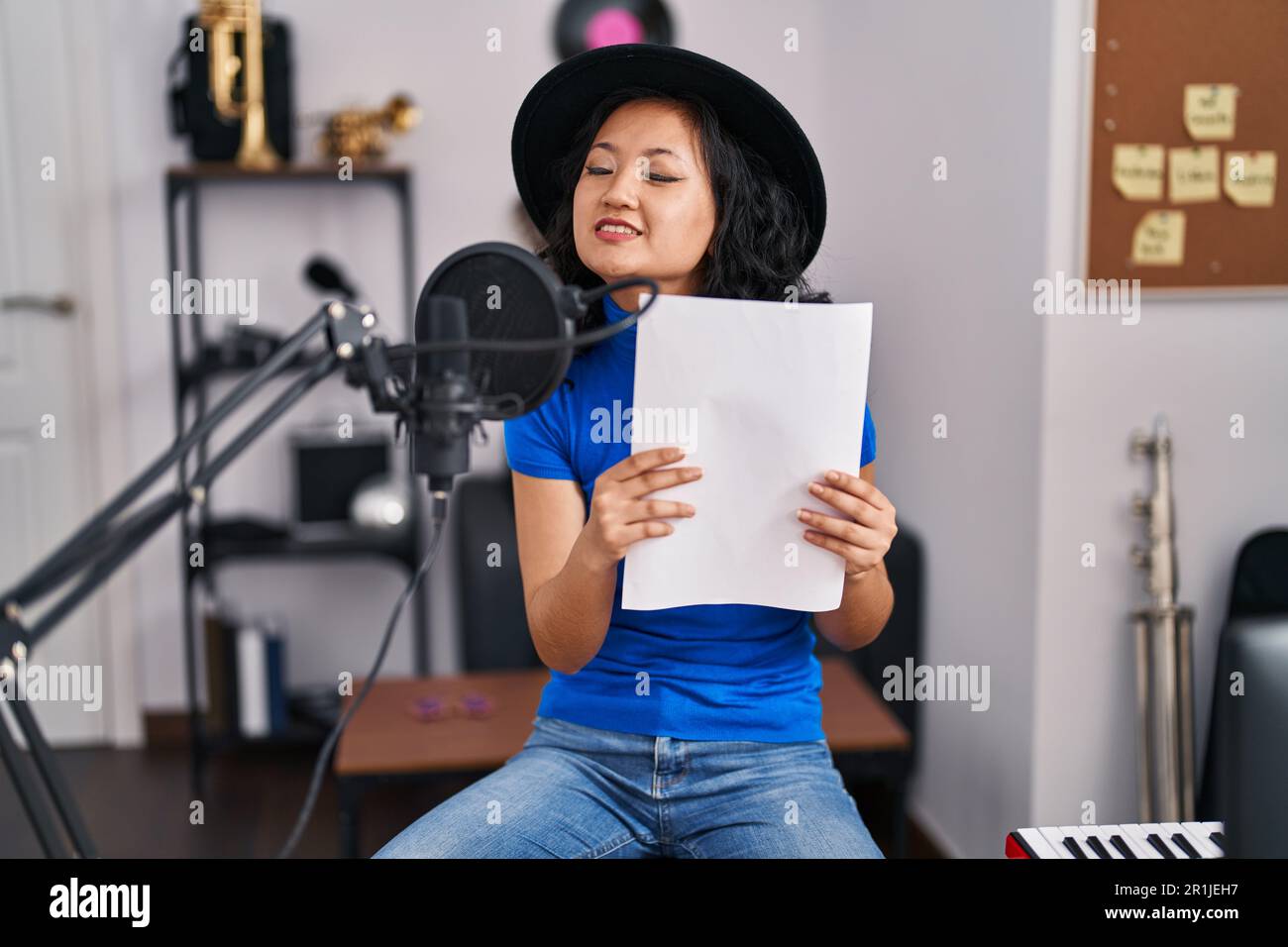 Young chinese woman artist singing song at music studio Stock Photo - Alamy