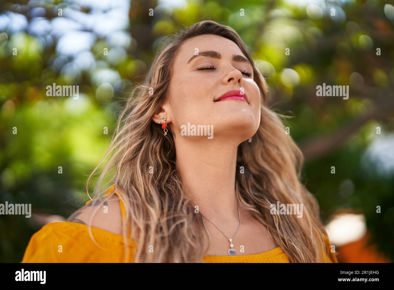 Young woman smiling confident breathing at park Stock Photo - Alamy