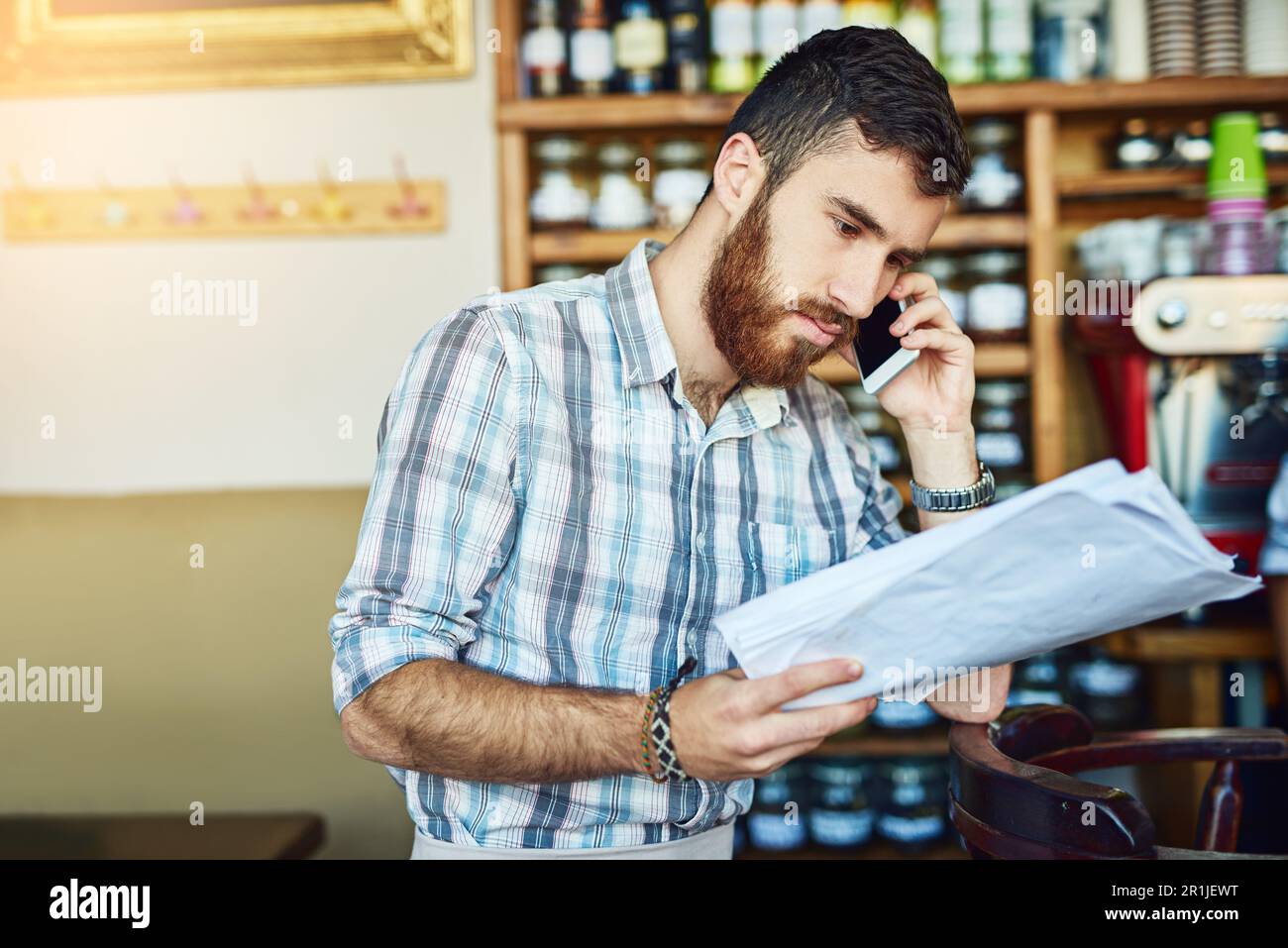 Putting in his monthly order. a shop owner talking on his cellphone ...