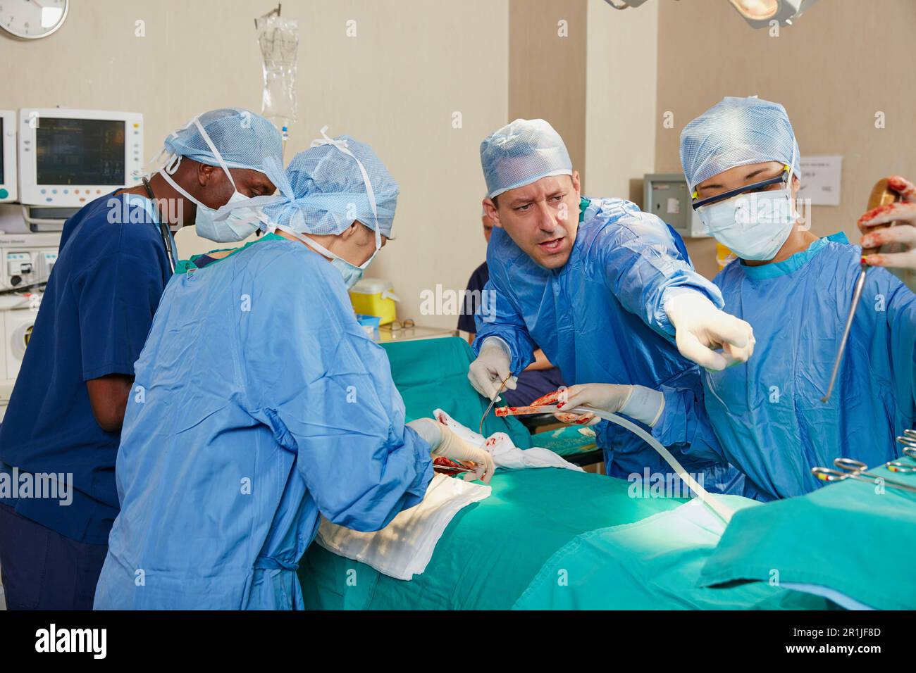 Scalpel, stat. a team of surgeons performing a surgery in an operating ...