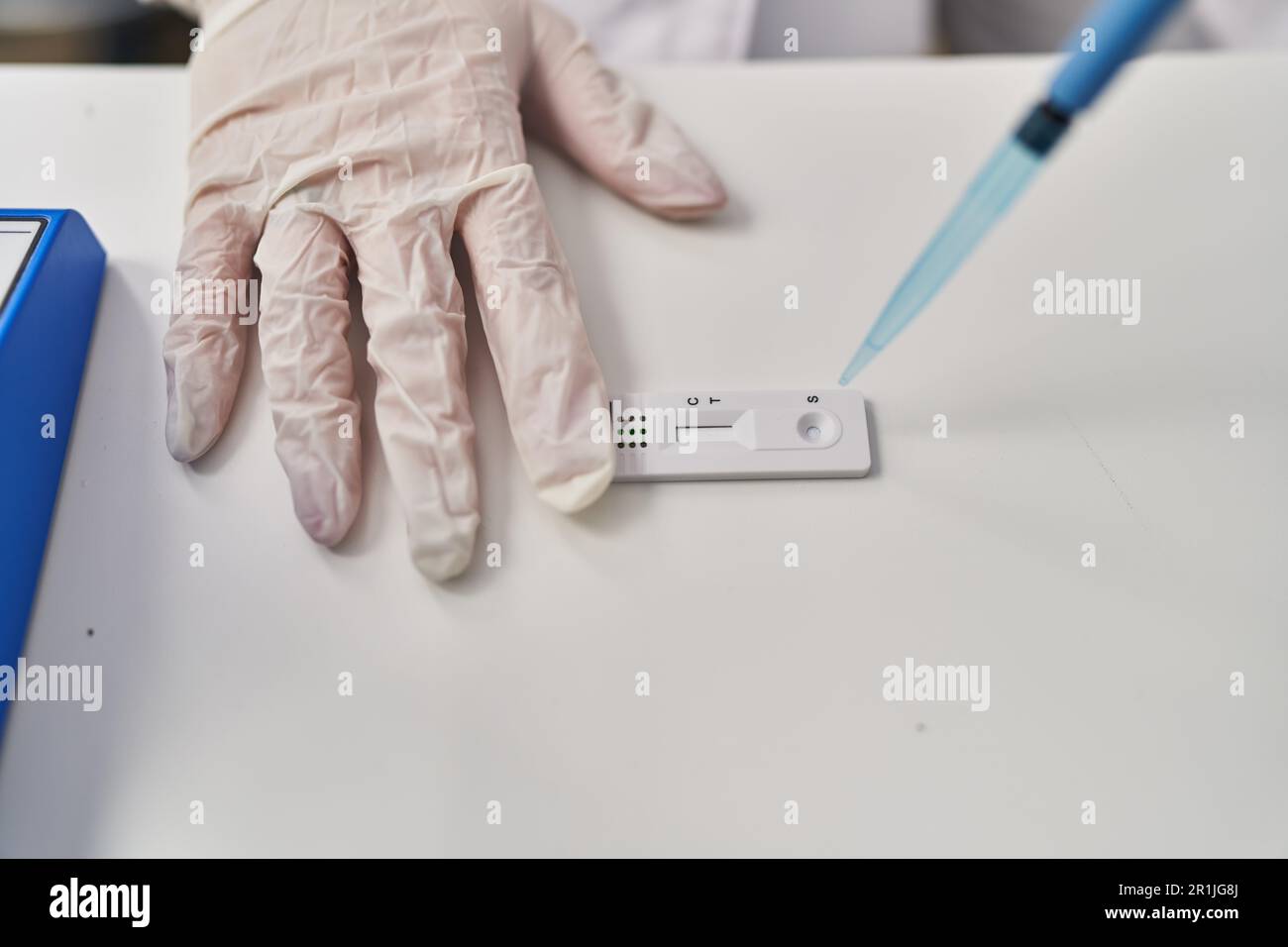 Young beautiful hispanic woman scientist pouring liquid to antigen test ...