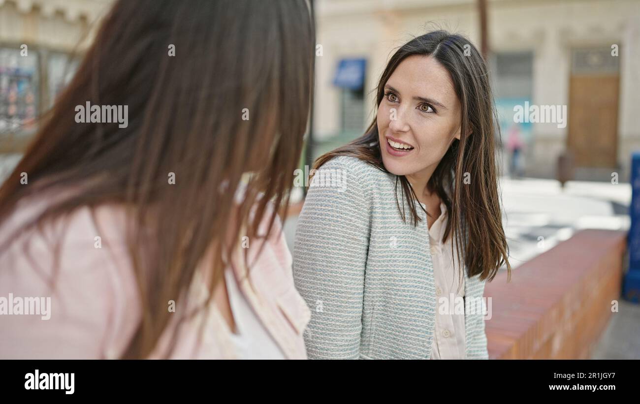 Two women smiling confident speaking at street Stock Photo - Alamy