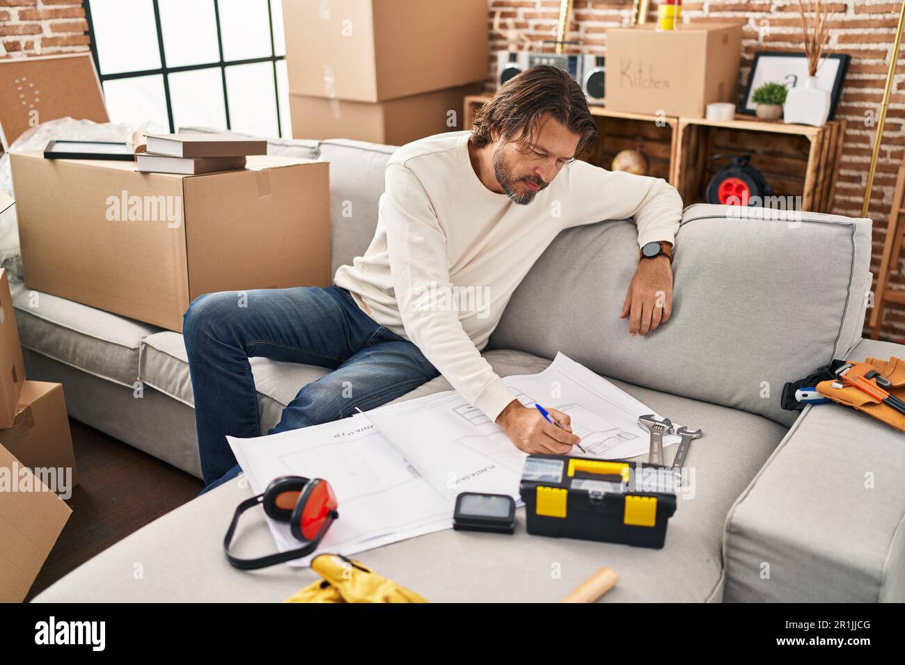 Middle age man drawing on house plans at new home Stock Photo - Alamy