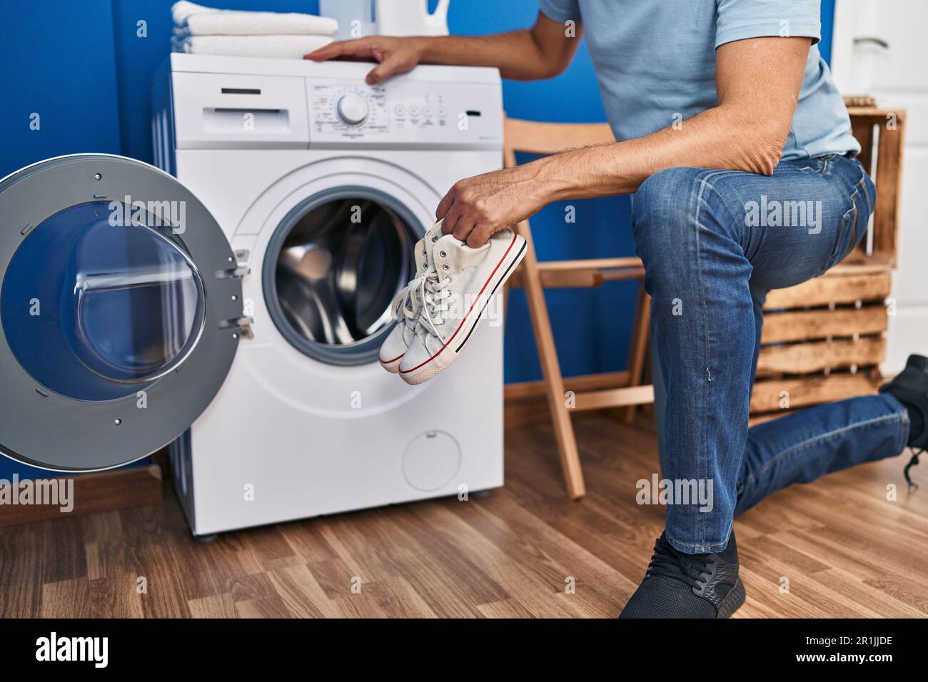 Middle age man washing sneakers at laundry room Stock Photo - Alamy