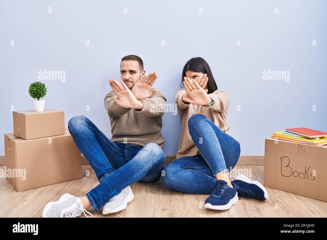 Young couple moving to a new home rejection expression crossing arms ...