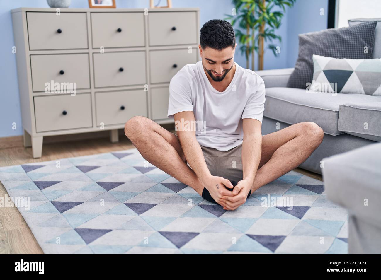 Young arab man smiling confident stretching at home Stock Photo - Alamy