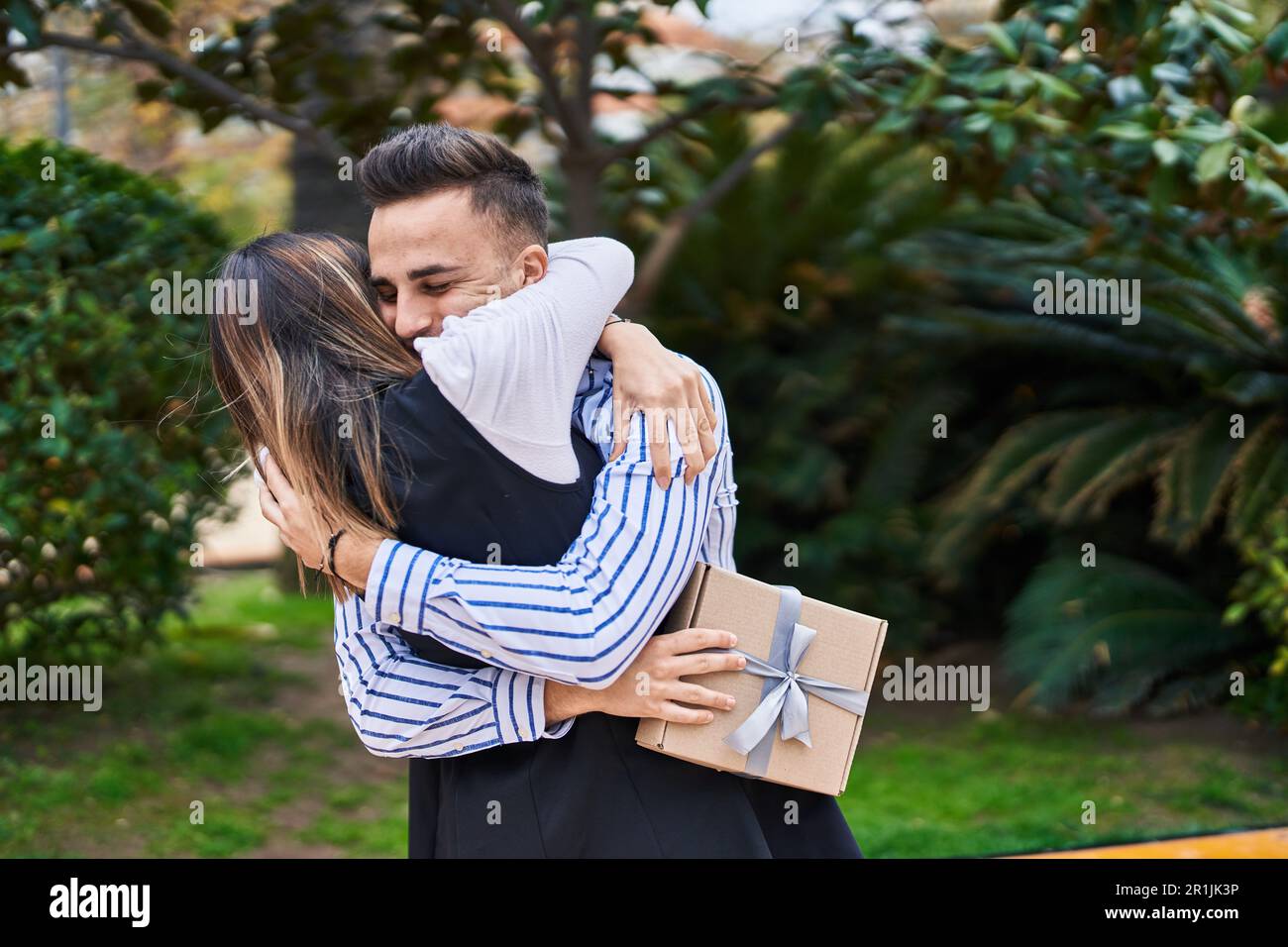 Man and woman couple hugging each other surprise with birthday gift at ...