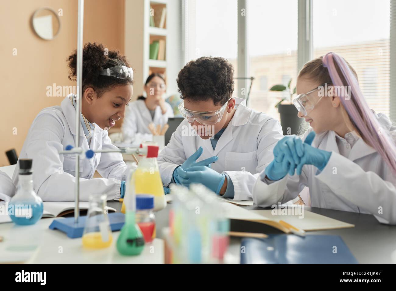 Group of young schoolchildren enjoying science experiments in class and ...