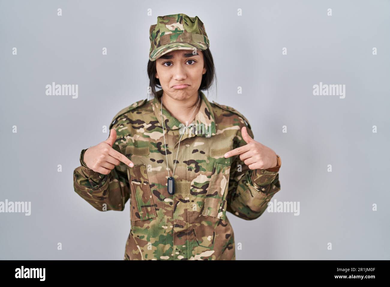 Young south asian woman wearing camouflage army uniform pointing down ...