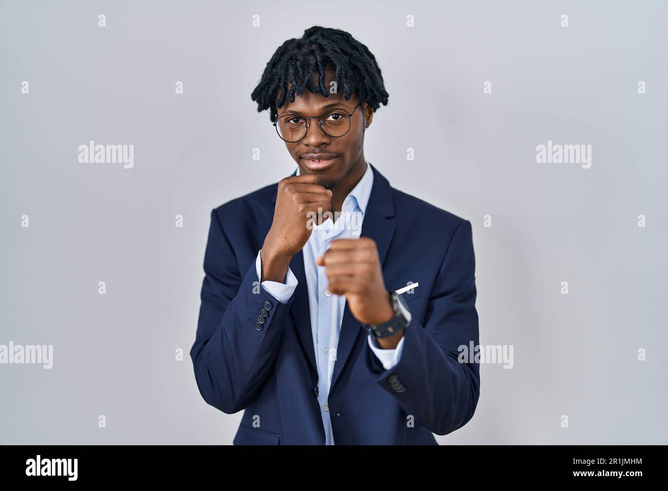 Young african man with dreadlocks wearing business jacket over white ...