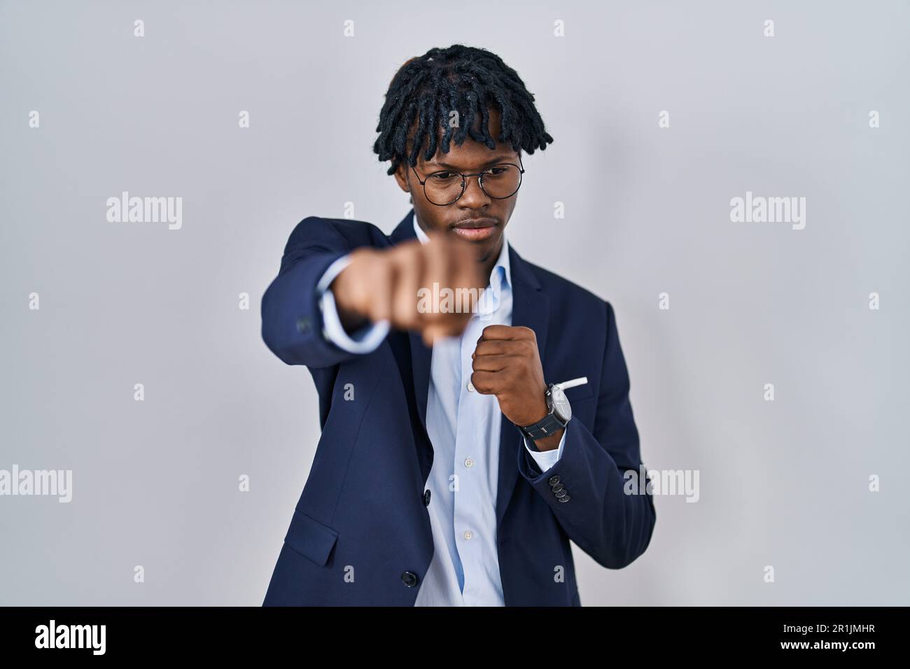 Young african man with dreadlocks wearing business jacket over white ...