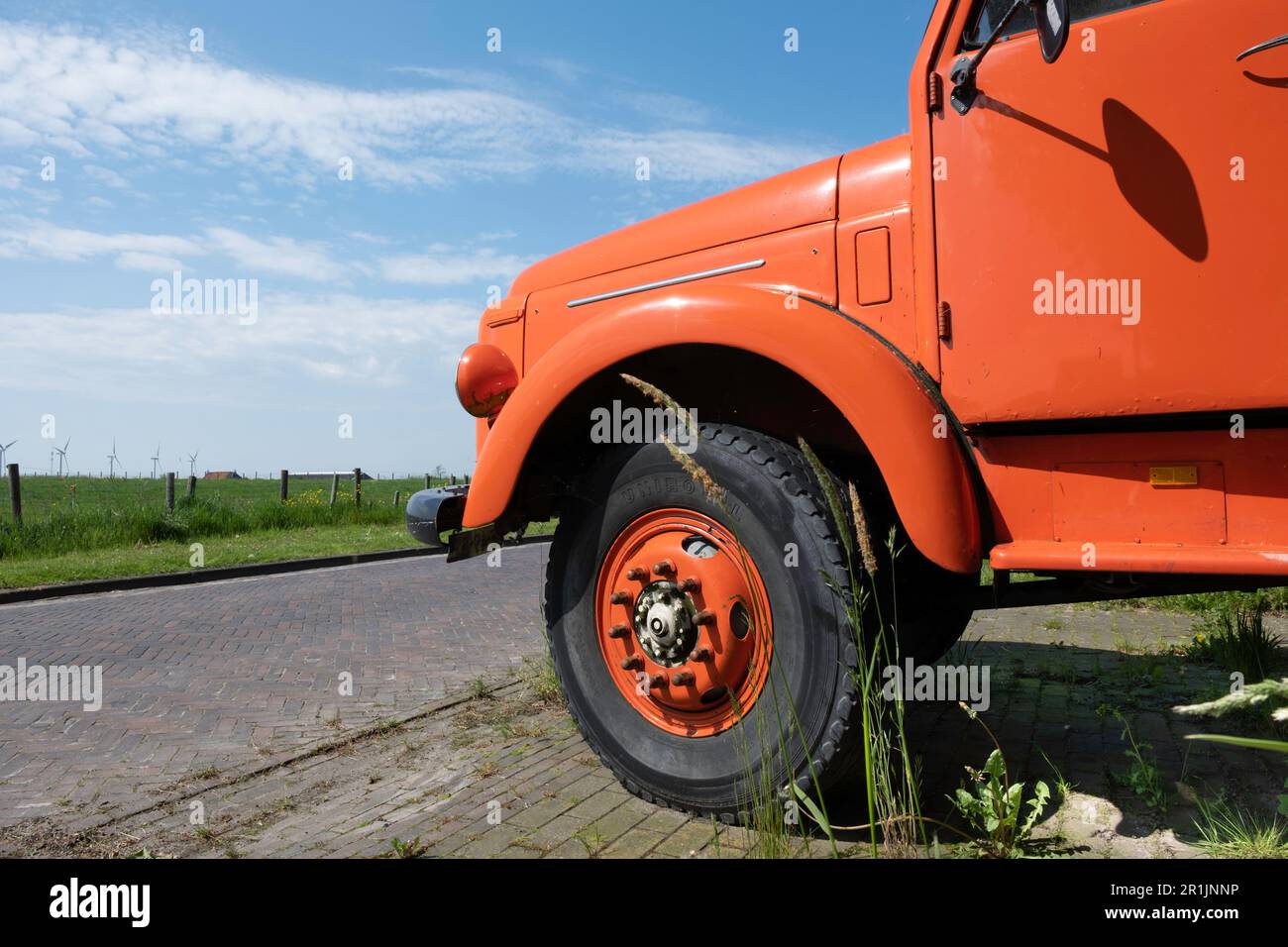 Classic red Volvo N88 truck drives up the road. Side view of the front ...