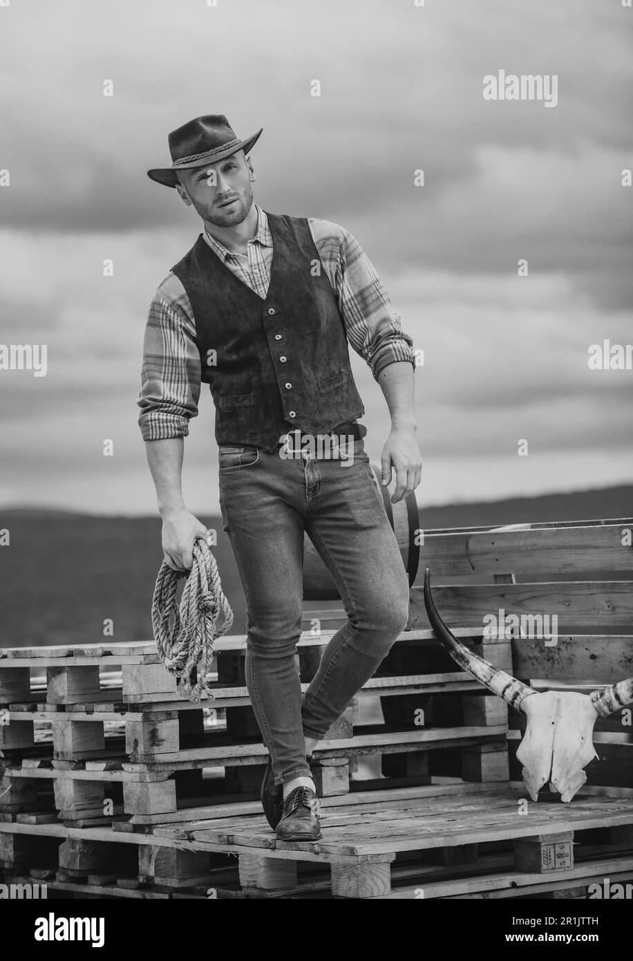 American cowboy man. Handsome brutal western guy. Cowboy with lasso ...