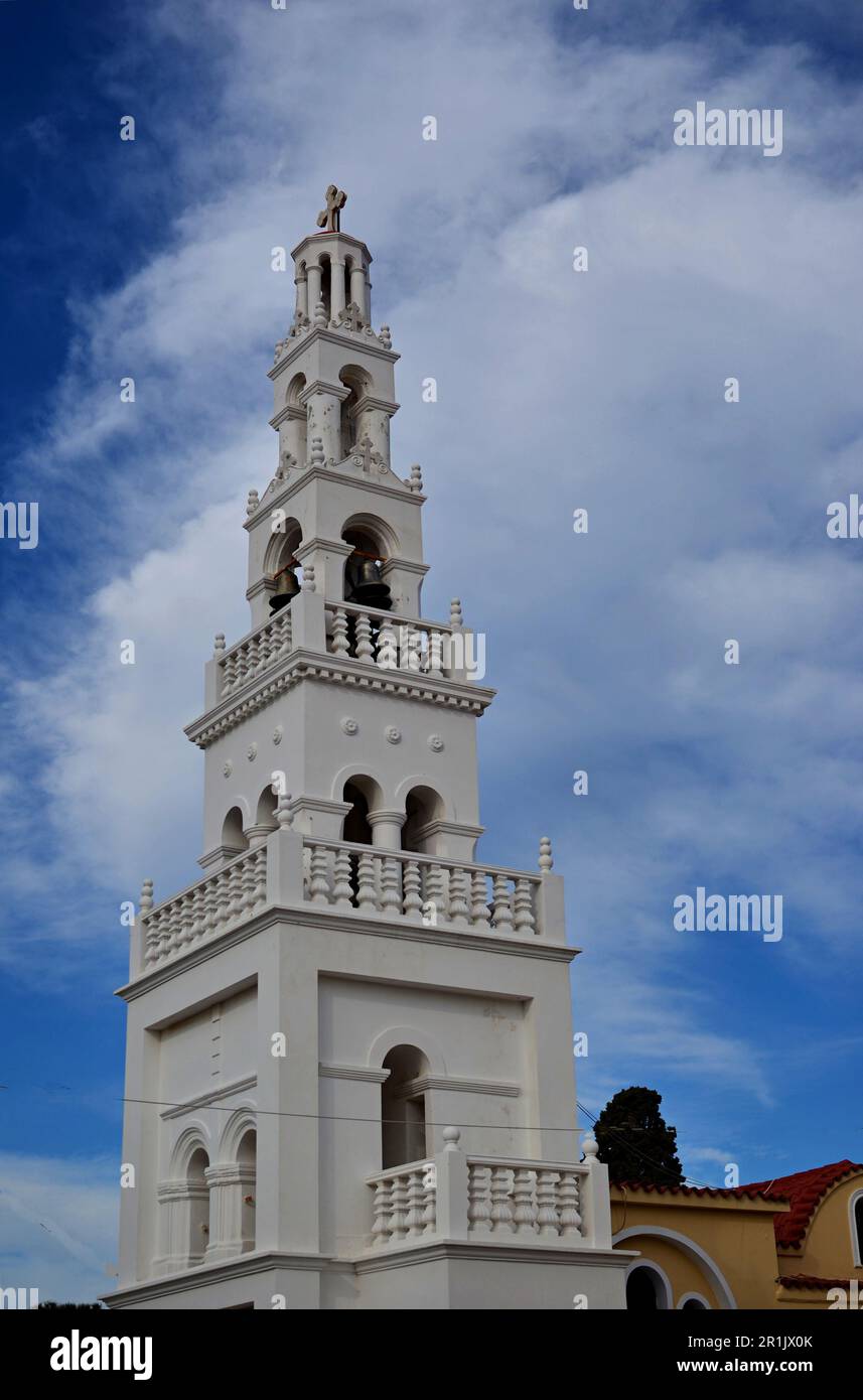 White church bell tower with bells against the blue sky and white ...