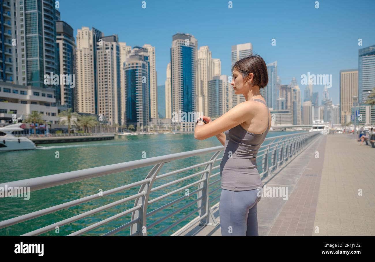 Young Asian female runner watch on heart rate monitor wrist watch band ...