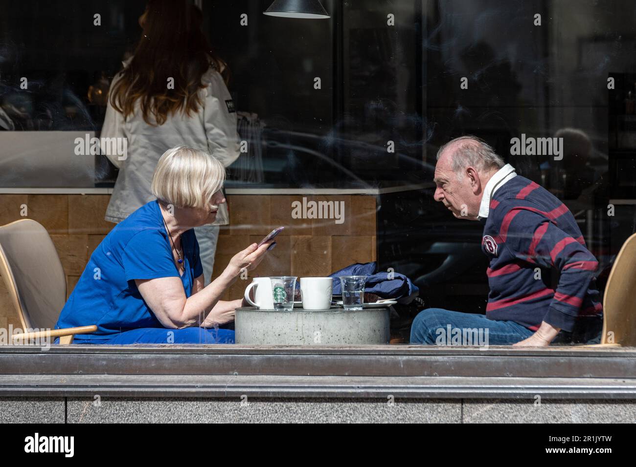 Elderly couple sitting by the window in a cafe in Helsinki, Finland ...