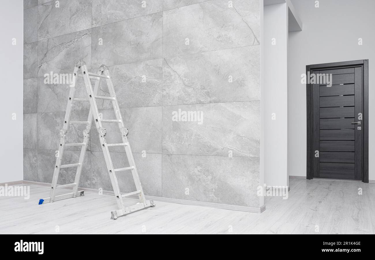 Empty room with tiled wall and ladder during repair Stock Photo - Alamy