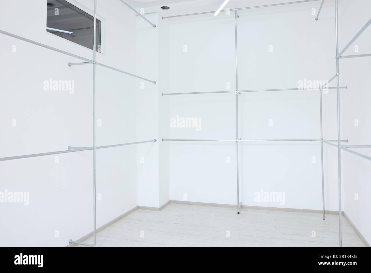 Empty room with beautiful white walls and garment racks during repair ...