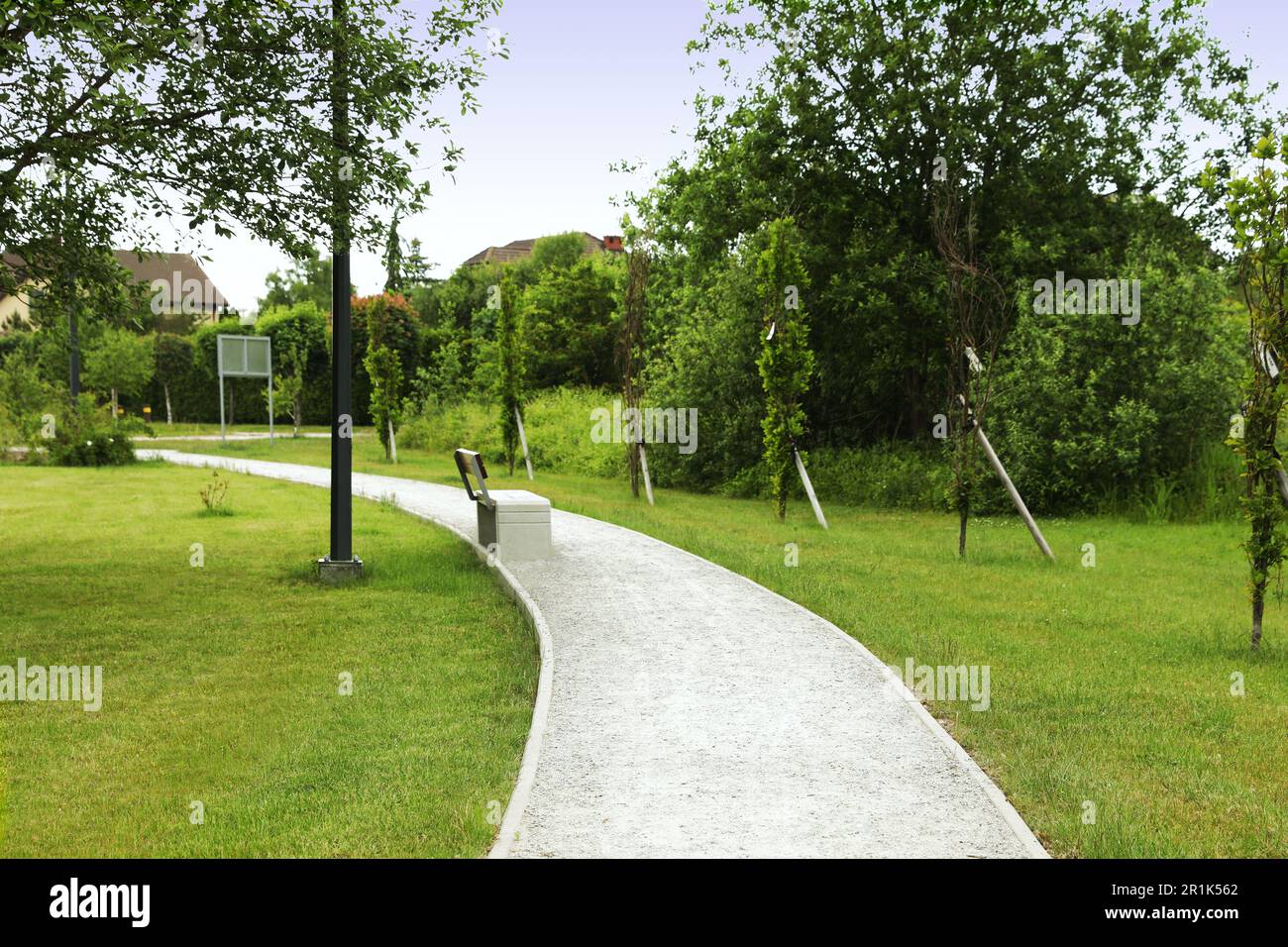 Beautiful green park with path and bench Stock Photo - Alamy