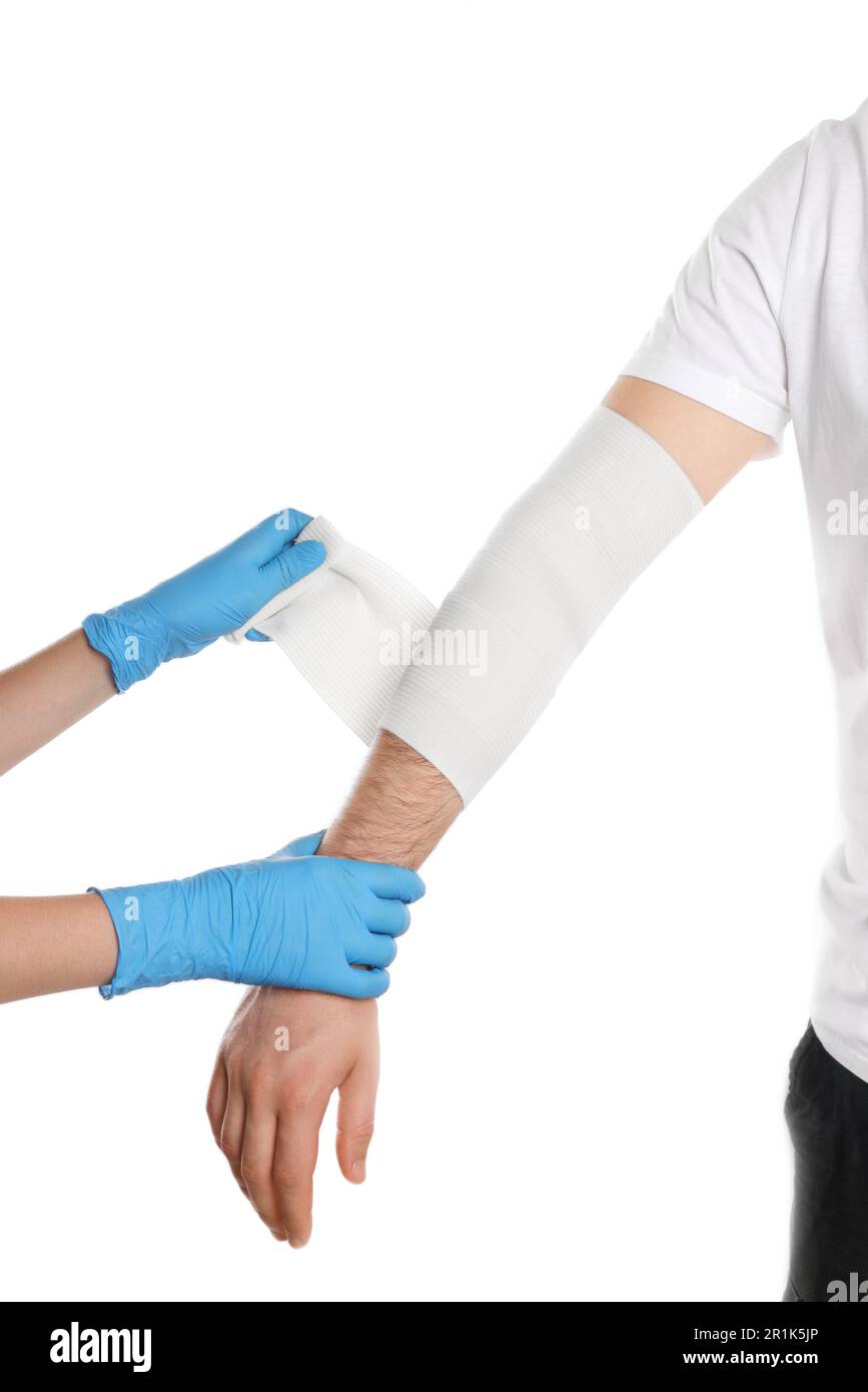 Doctor applying medical bandage onto patient's arm on white background ...