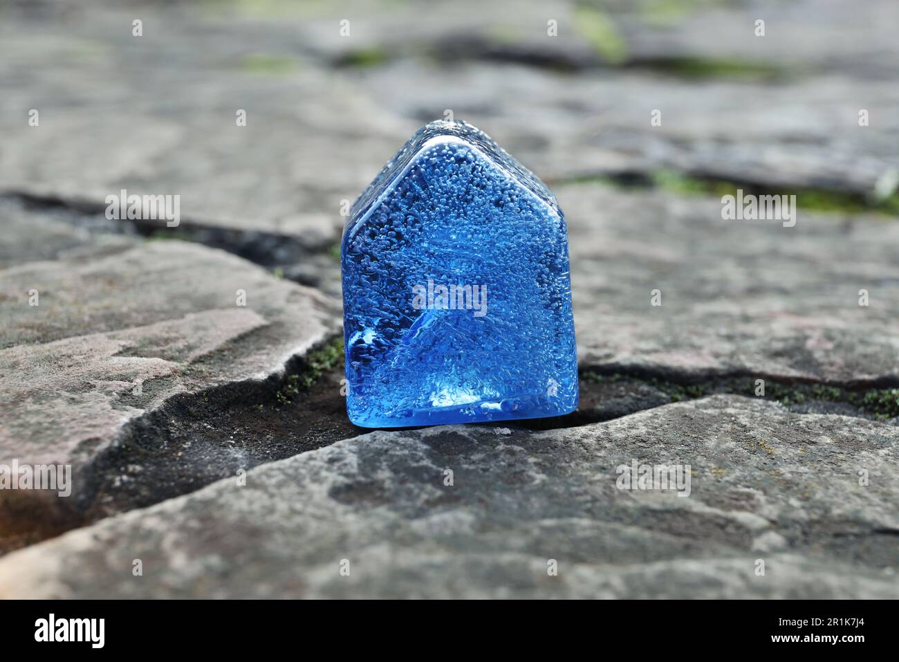 Glass house model between cracks on stone road. Earthquake disaster ...