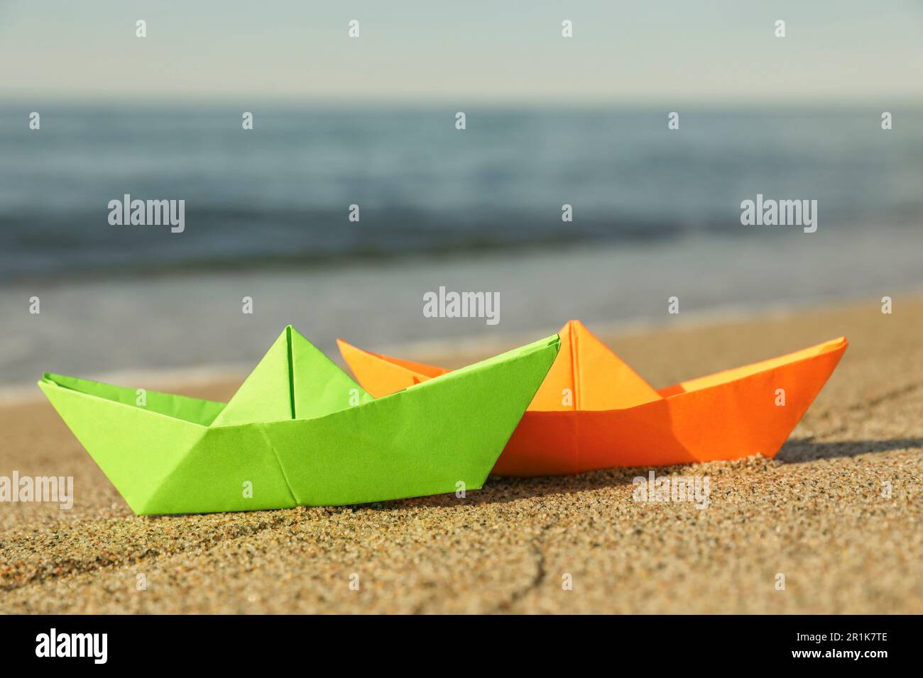Bright color paper boats on sandy beach near sea Stock Photo - Alamy