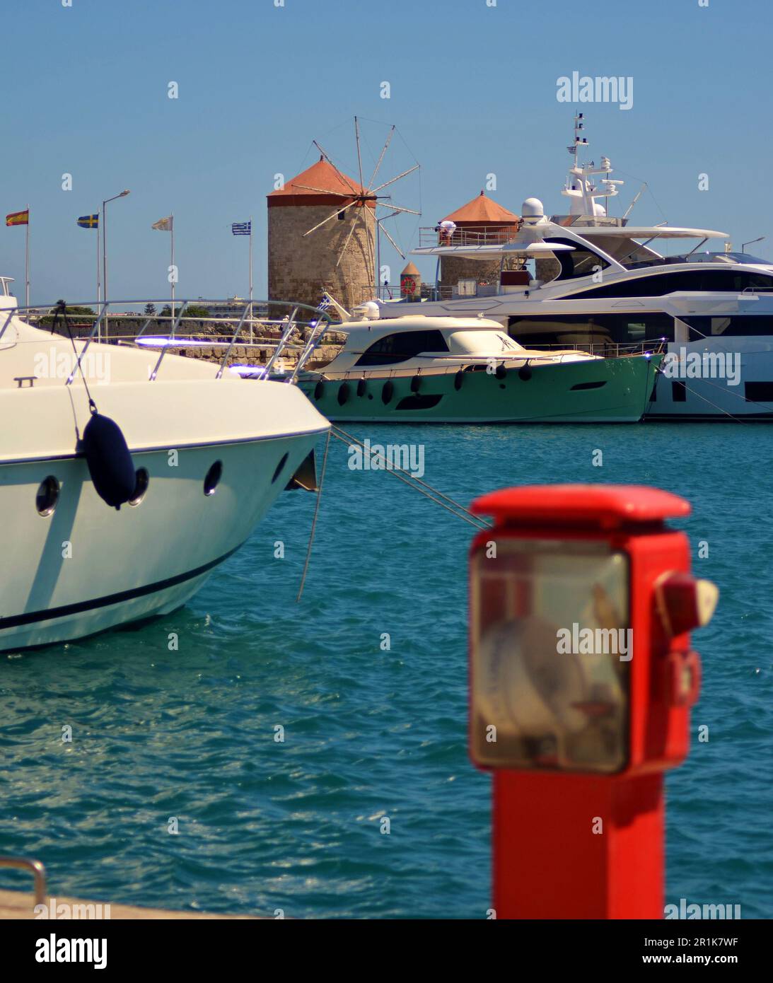 Medieval stone mills with red roofs in the port of Rhodes. Motor and ...