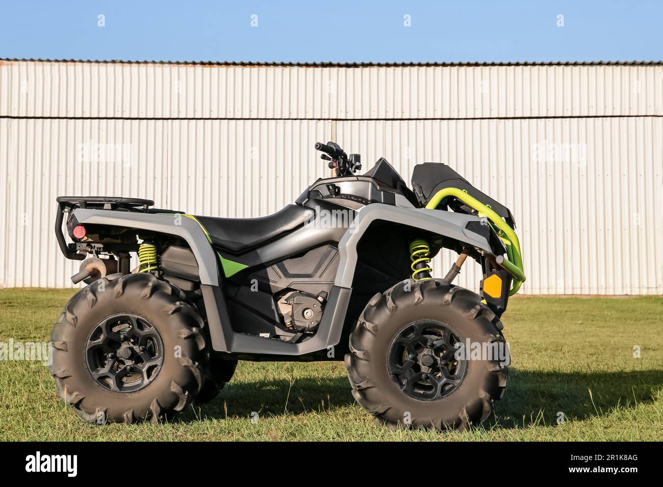 Modern quad bike in field near hangar on sunny day Stock Photo - Alamy