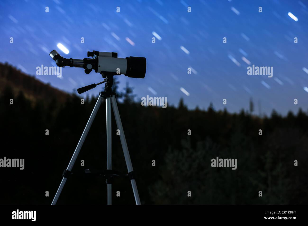 Modern telescope under night sky with star trails outdoors. Learning ...