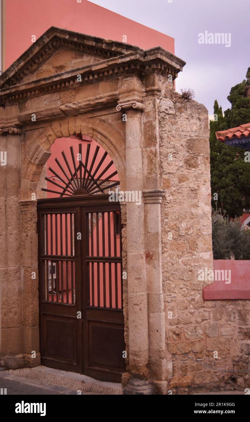Entrance door with stone columns and a portico above the door. Behind ...