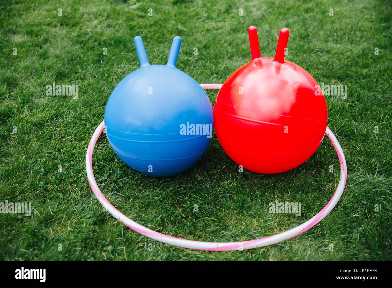 bouncing balls or hoppers and hula hoop on grass Stock Photo - Alamy
