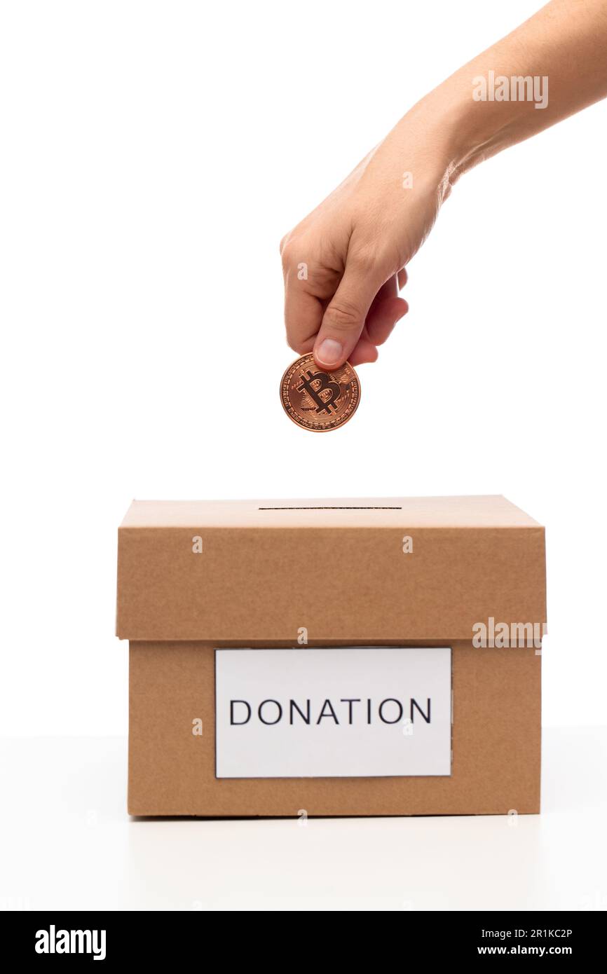 hand putting bitcoin into charity donation box Stock Photo - Alamy
