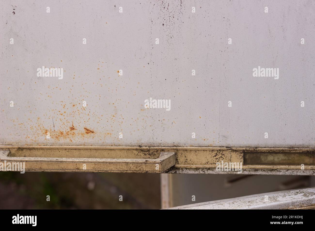 An old rusty refrigerator was thrown away on the street in sun light ...